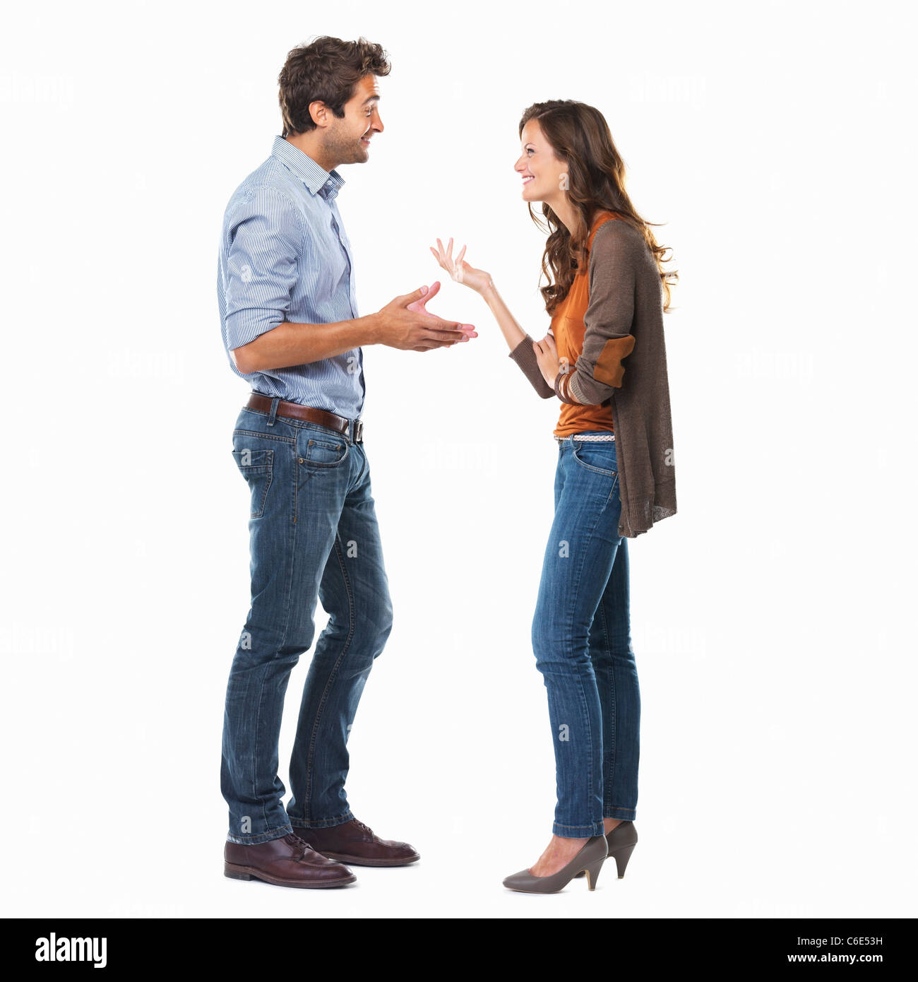 Studio shot of young couple having conversation Stock Photo - Alamy