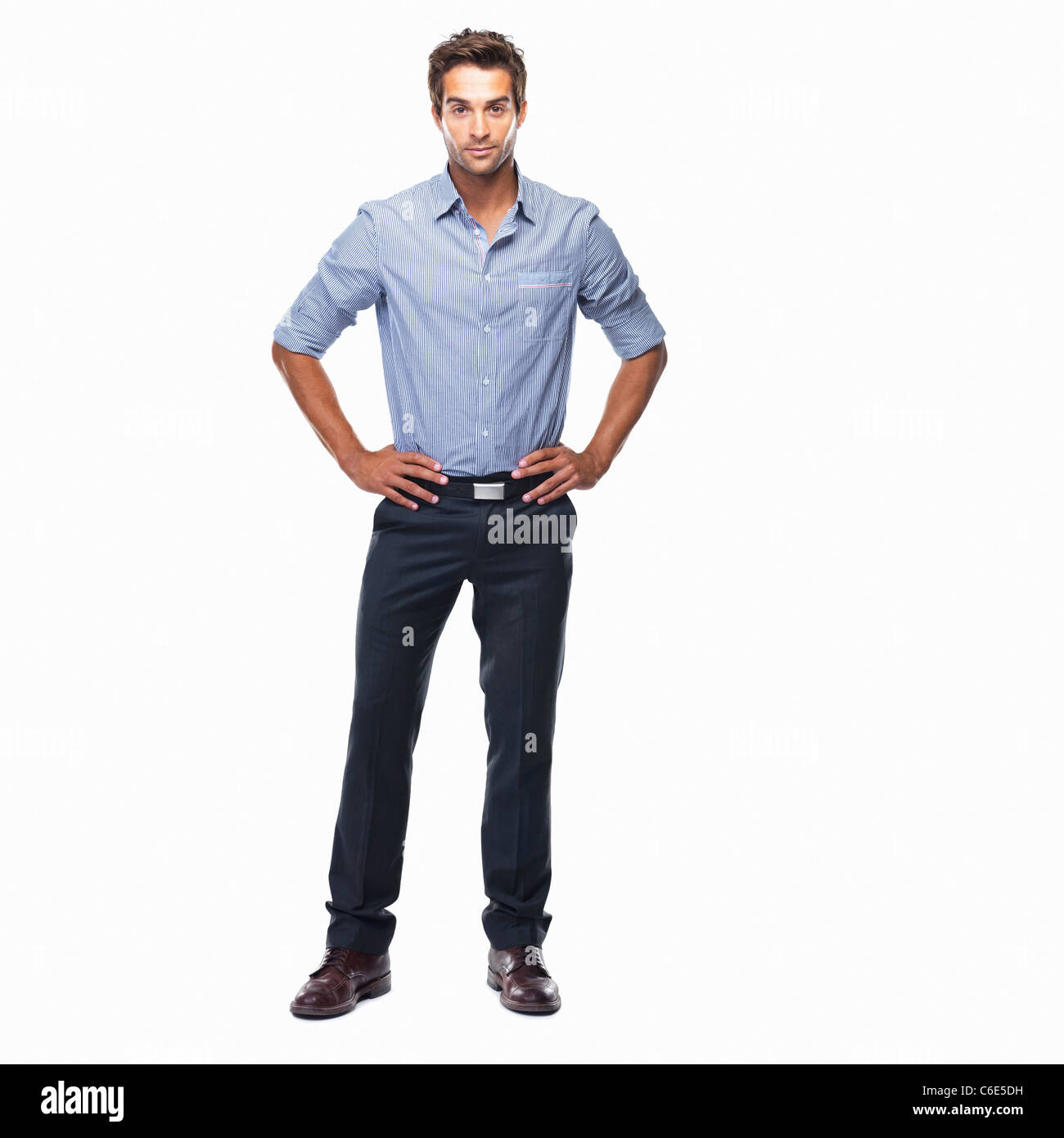 Studio shot of attractive business man standing with hands on hips ...