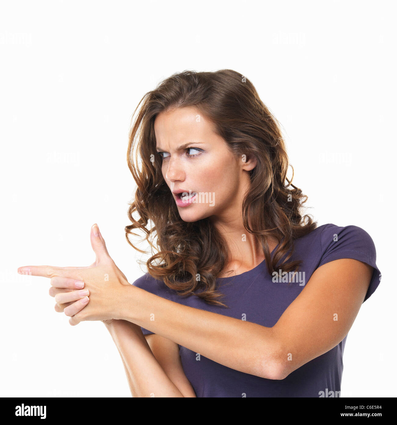 Studio portrait of making gun shape with both hands and pointing away ...