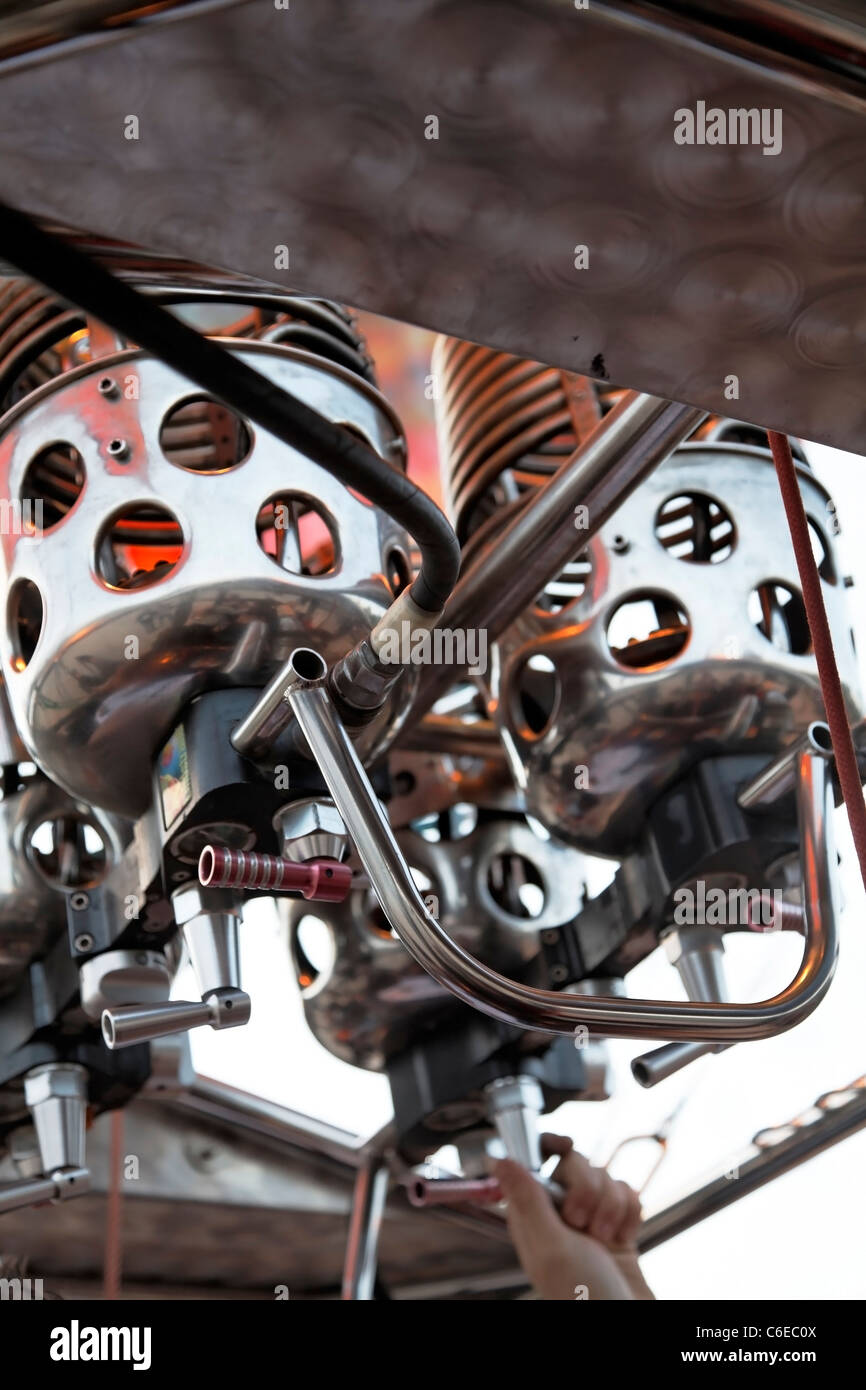 pilot manning the controls of a hot air balloon engine and jets during ...