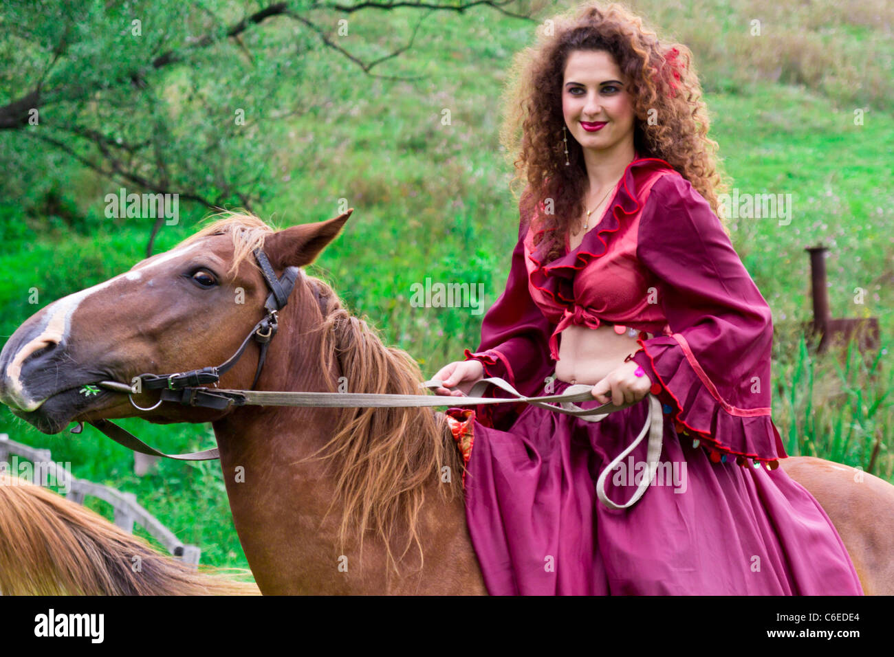 Beautiful gypsy girl riding a horse in the field Stock Photo - Alamy