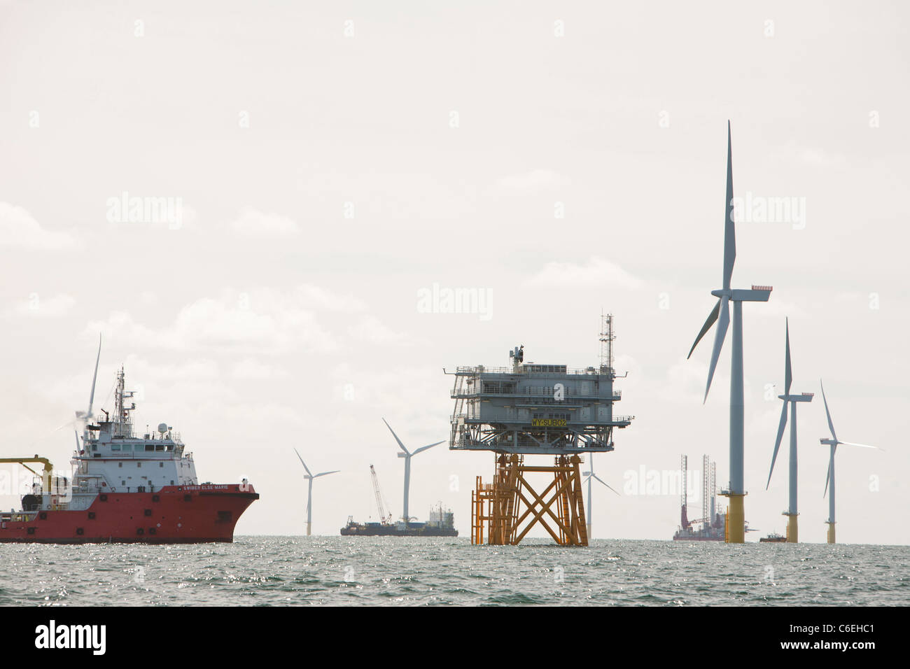 A cable laying vessel next to a sub station at the Walney offshore wind ...