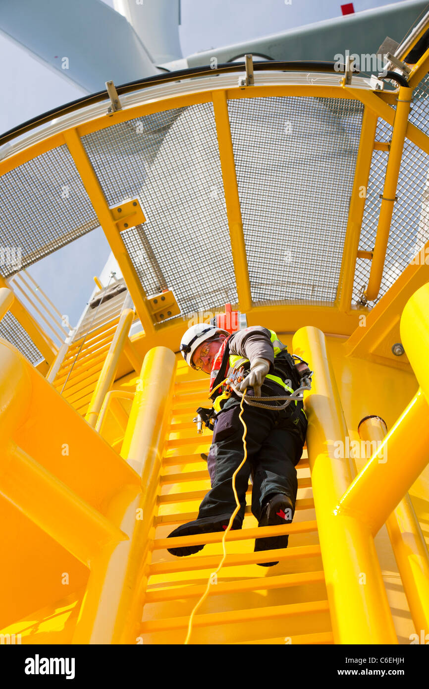 An engineer climbs a transition piece of a wind turbine on the Walney ...