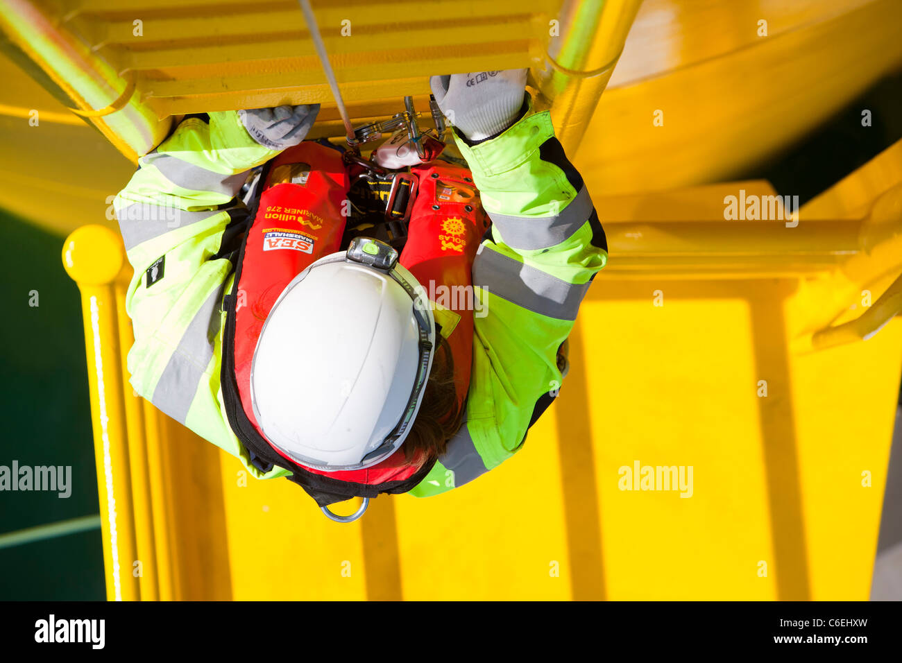 An engineer climbs a transition piece of a wind turbine on the Walney ...