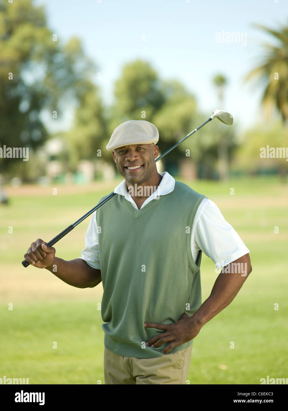 USA, Arizona, Scottsdale, Smiling man on golf course holding golf club ...