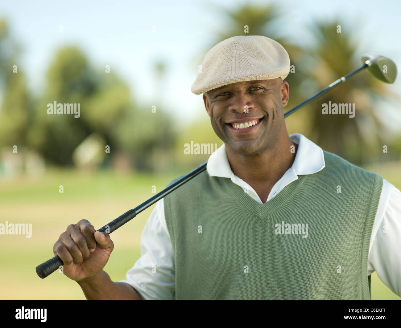 USA, Arizona, Scottsdale, Smiling man on golf course holding golf club ...