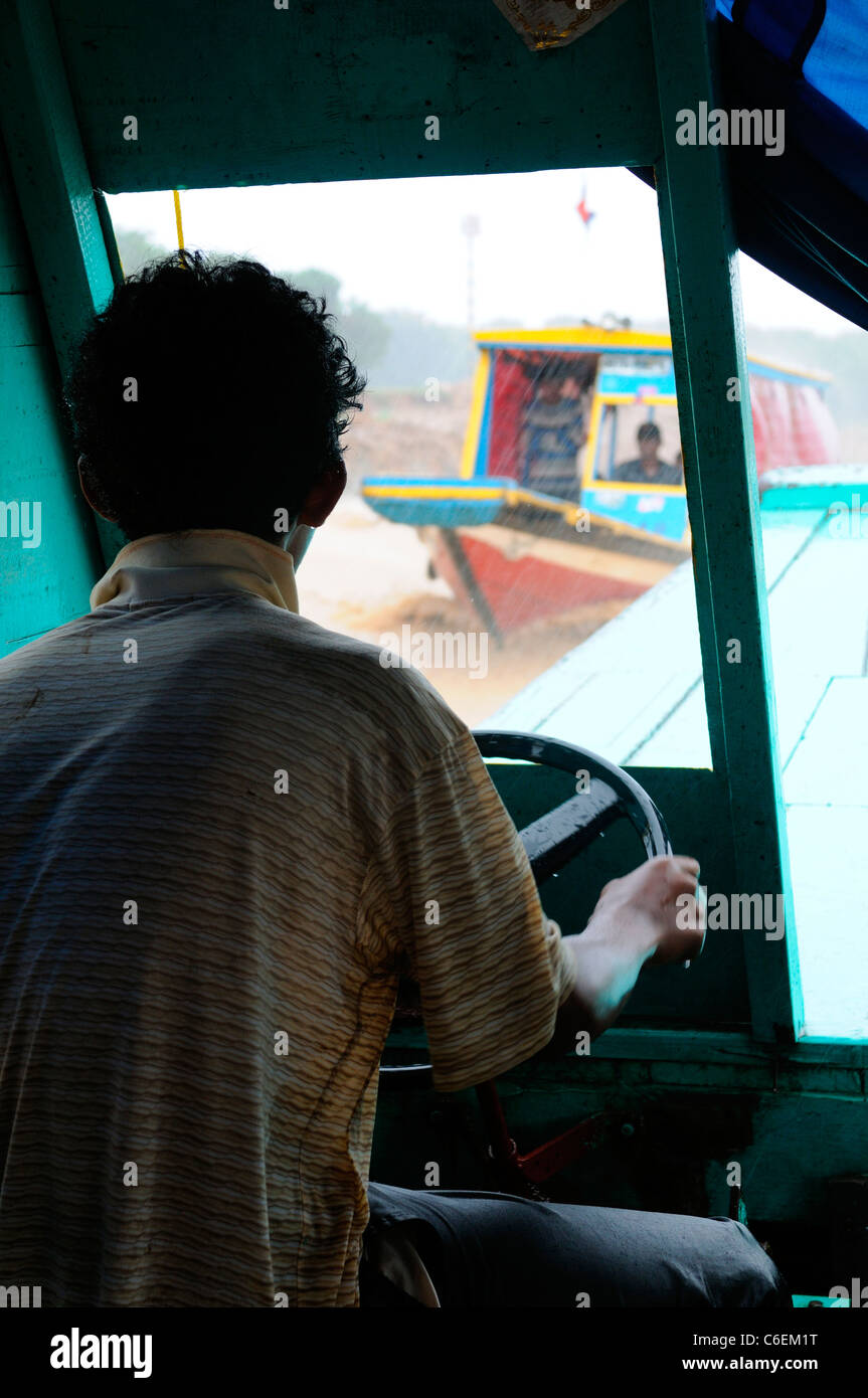 man drive driving sail sailing houseboat boat Tonle Sap freshwater lake ...