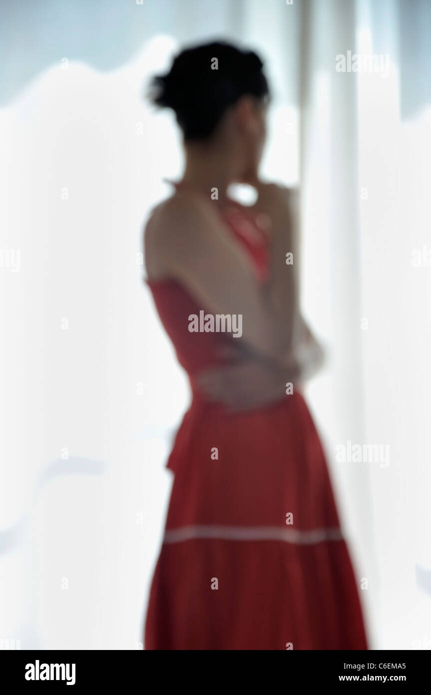 Young woman standing at the window Stock Photo - Alamy