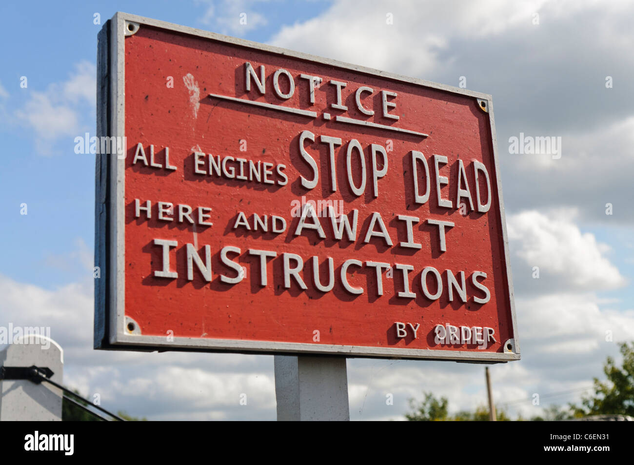 Sign on a railway instructing drivers to stop dead and await ...