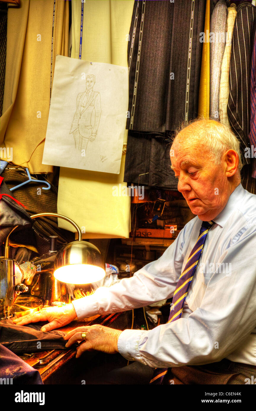 Tailor stitching a suit at work on his singer sewing machine old man ...