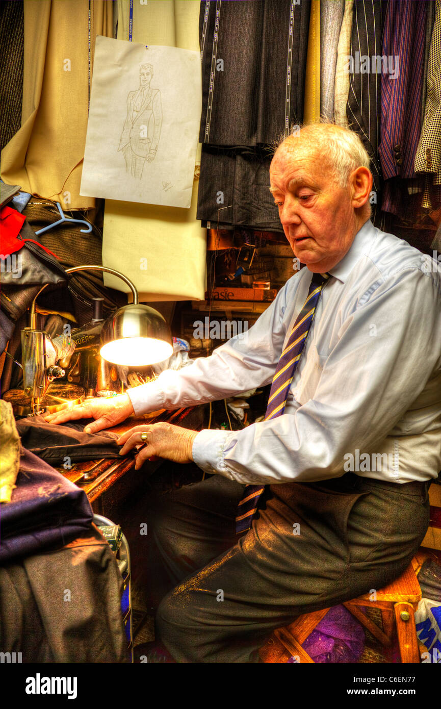 Tailor stitching a suit at work on his singer sewing machine old man ...