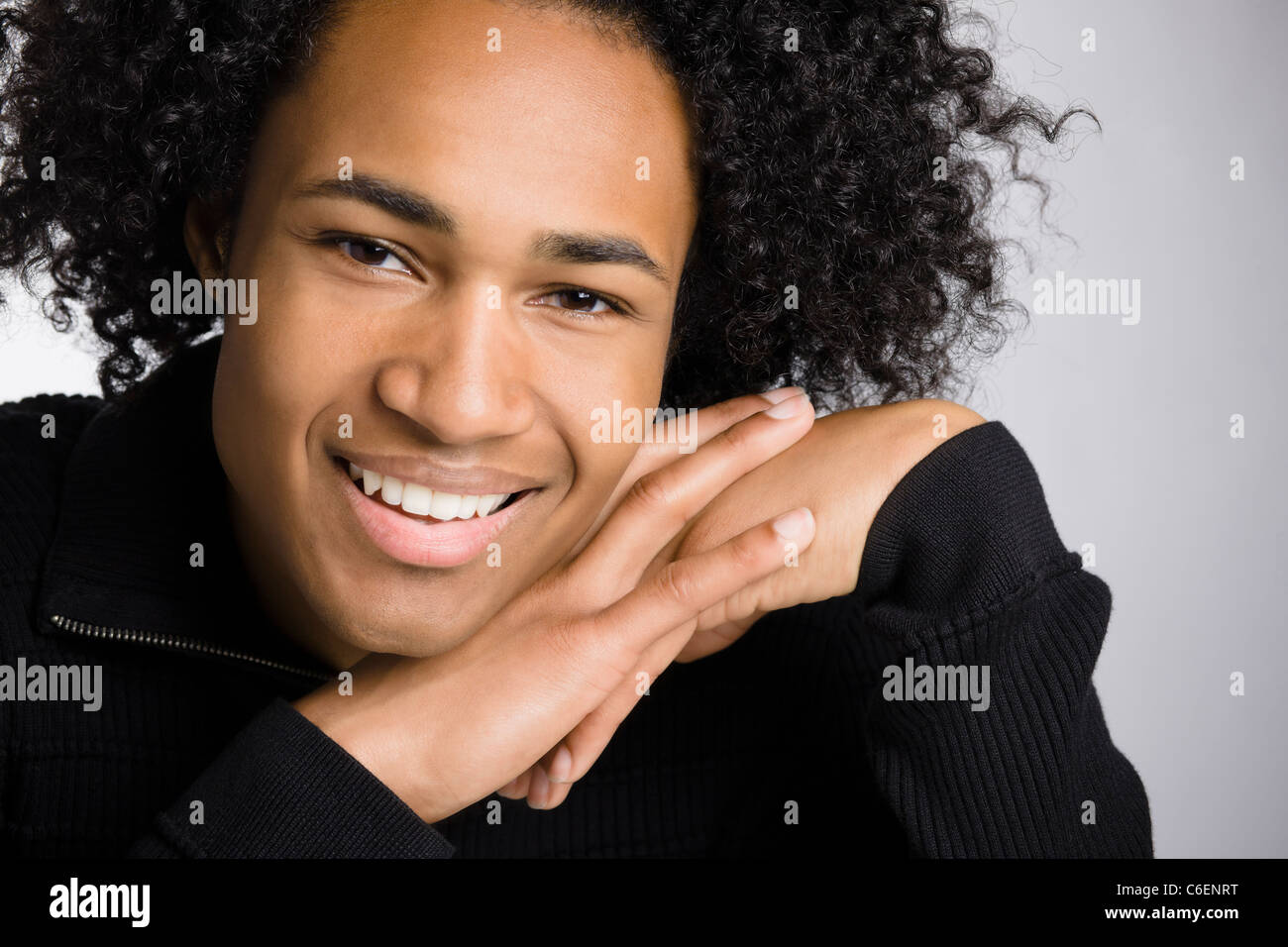 Smiling mixed race man with hands clasped Stock Photo - Alamy