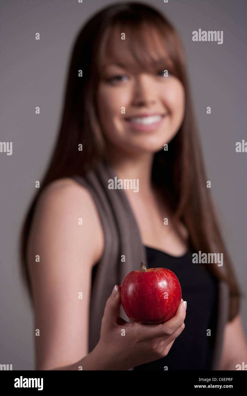 Portrait of teenage girl with red apple, studio shot Stock Photo - Alamy