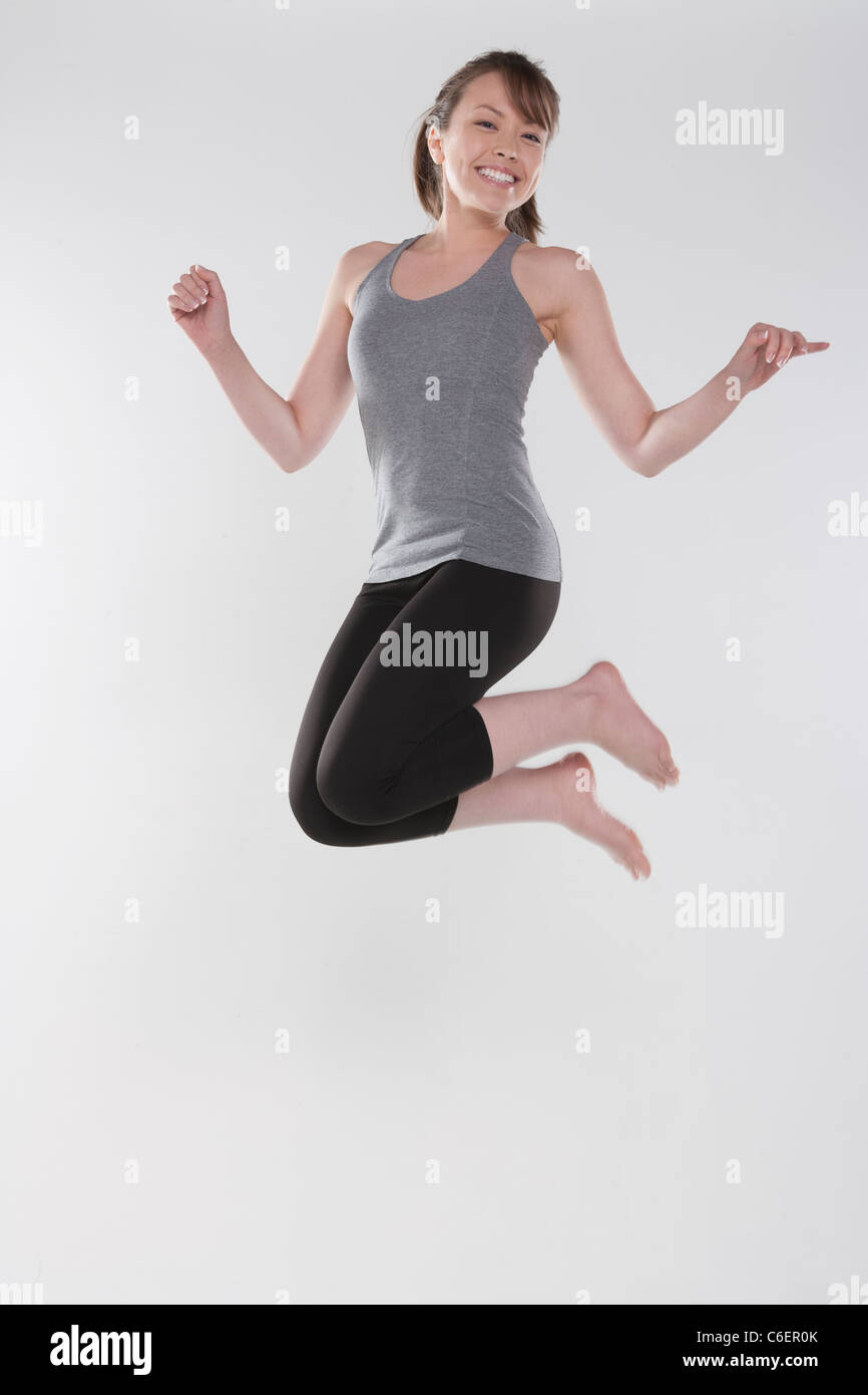 Portrait of young woman jumping, studio shot Stock Photo - Alamy