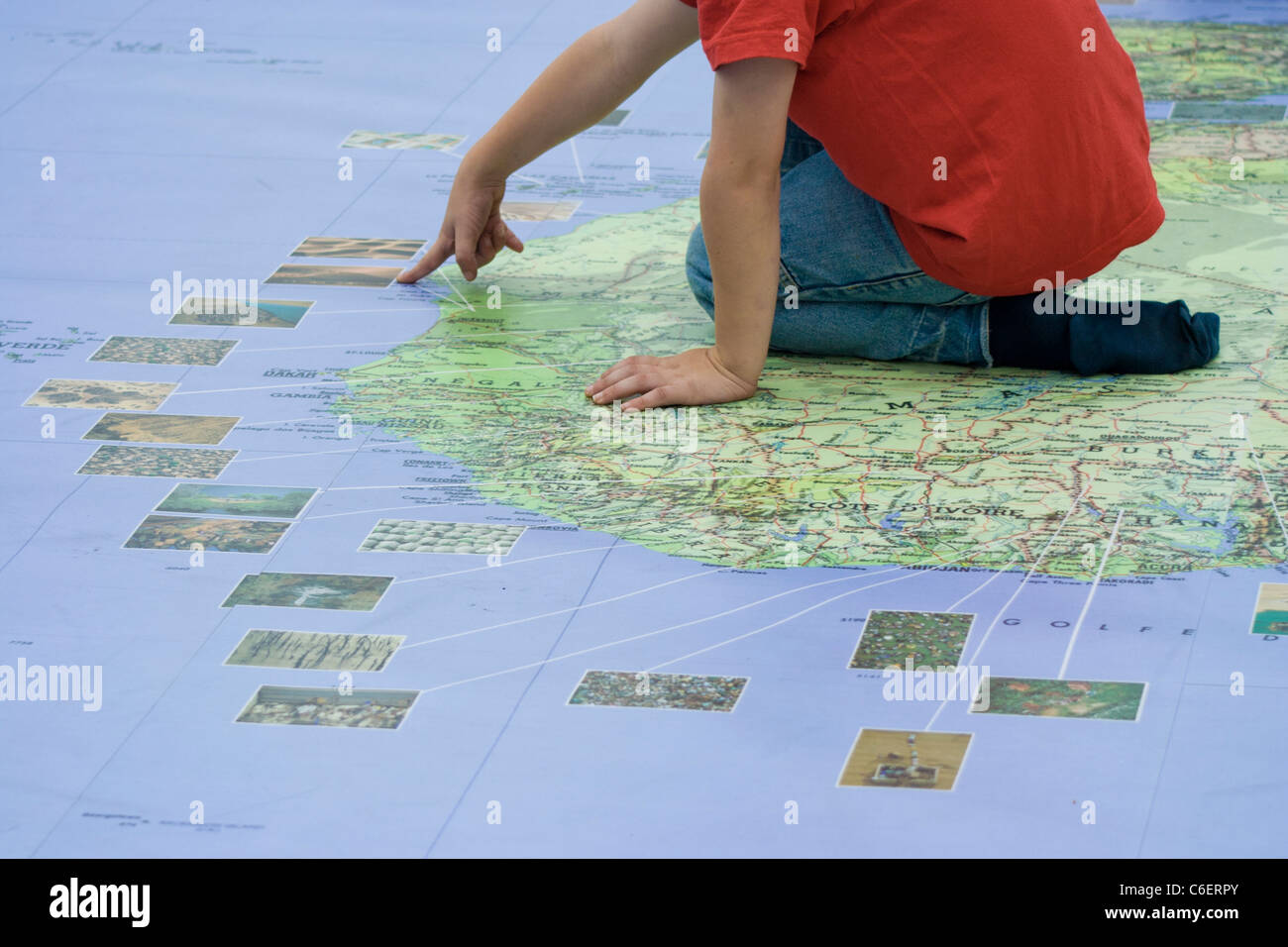 A boy sitting on a map Stock Photo - Alamy