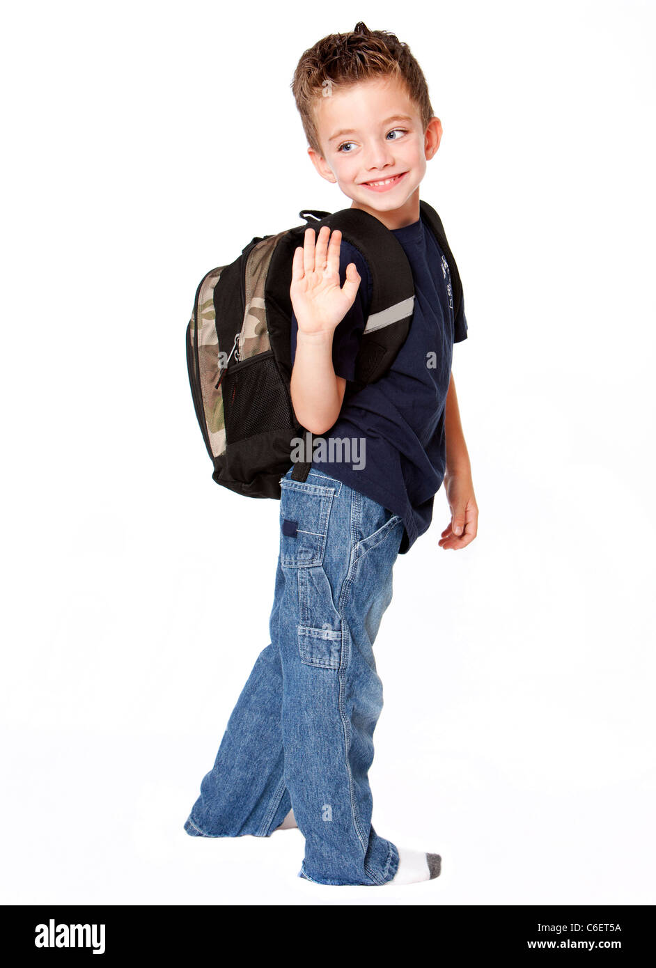 Young boy with backpack waving goodbye Stock Photo - Alamy