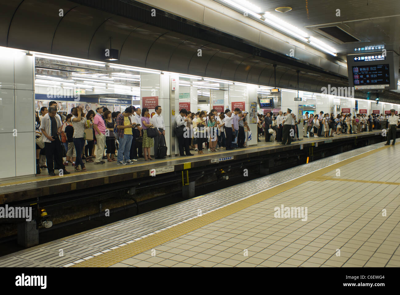 People waiting for train on subway platform, Japan Stock Photo - Alamy