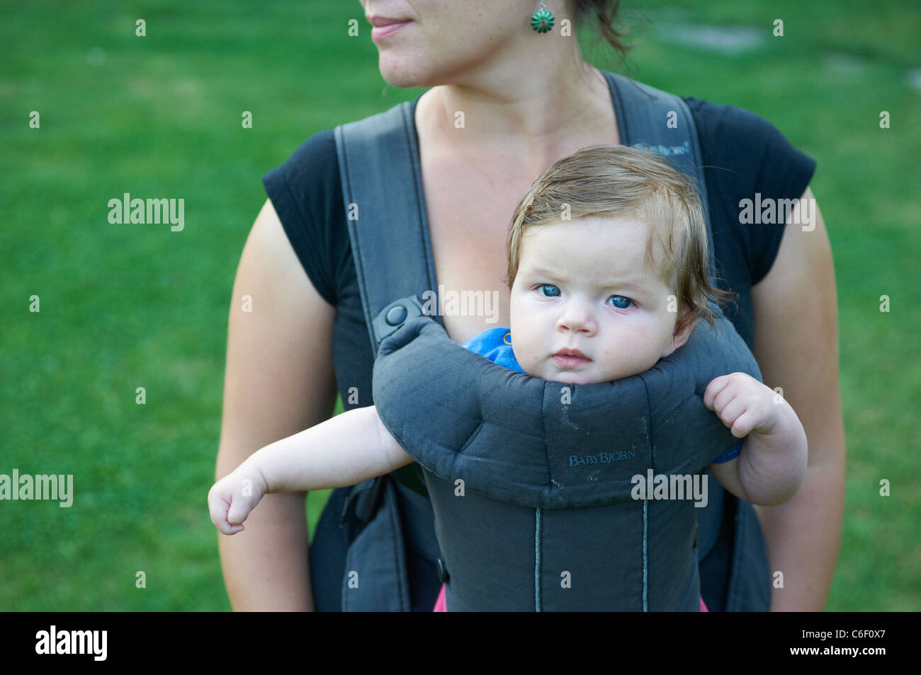 Mother carrying baby in baby carrier outside Stock Photo - Alamy