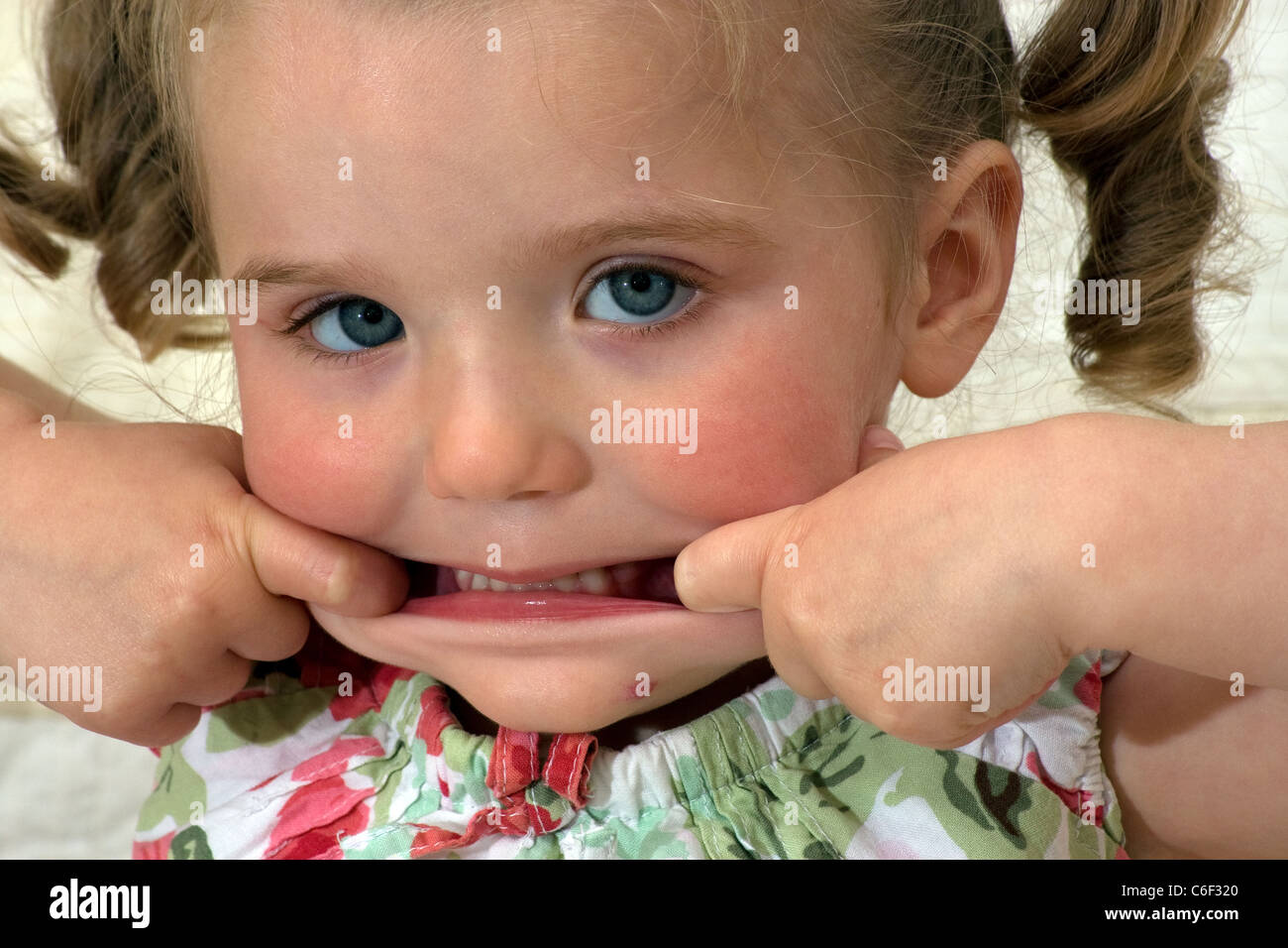 young toddlers girl face pulling cute pull a Stock Photo - Alamy