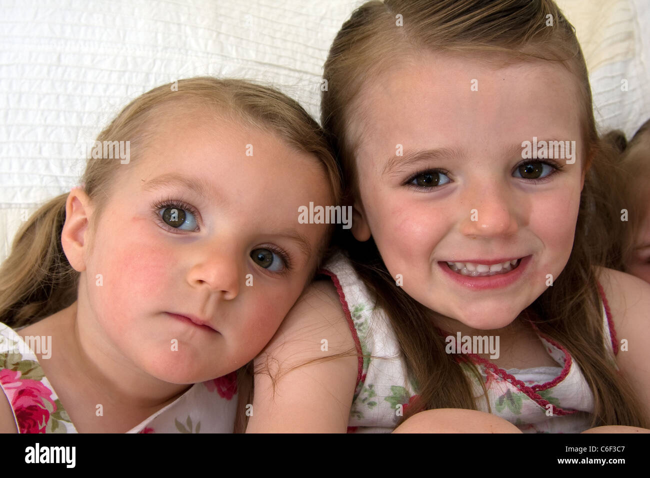 young toddler girls sisters smile curious Stock Photo - Alamy