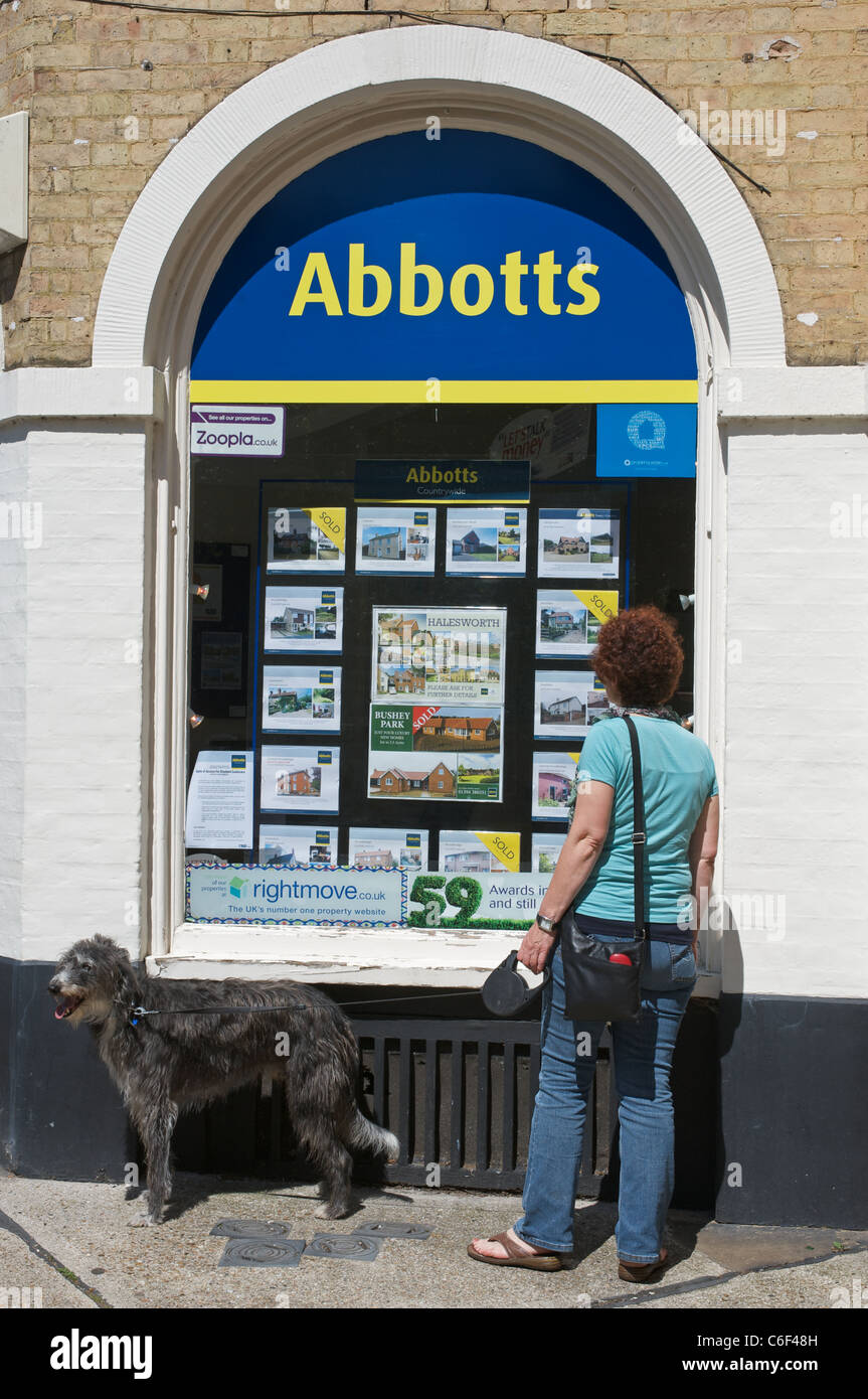 Woman looking in estate agents window Stock Photo - Alamy