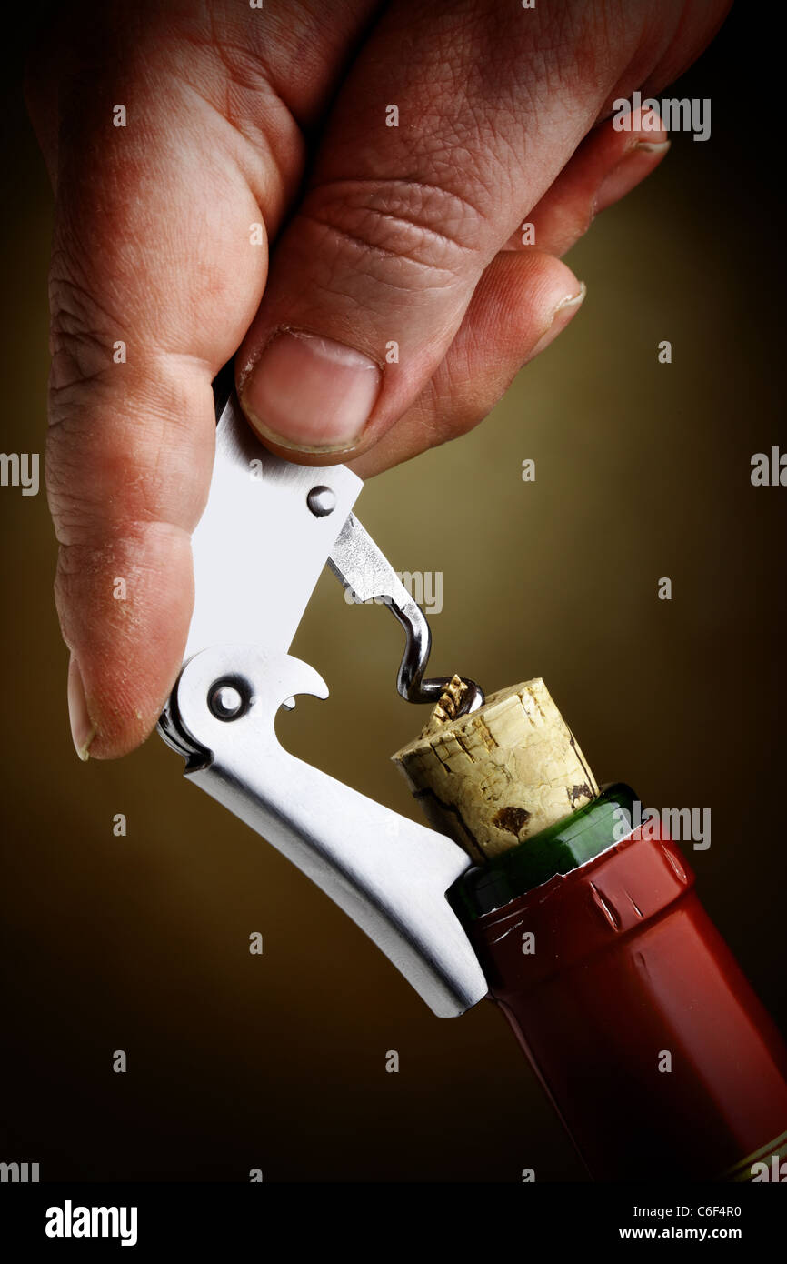 Opening wine bottle over dark background Stock Photo - Alamy