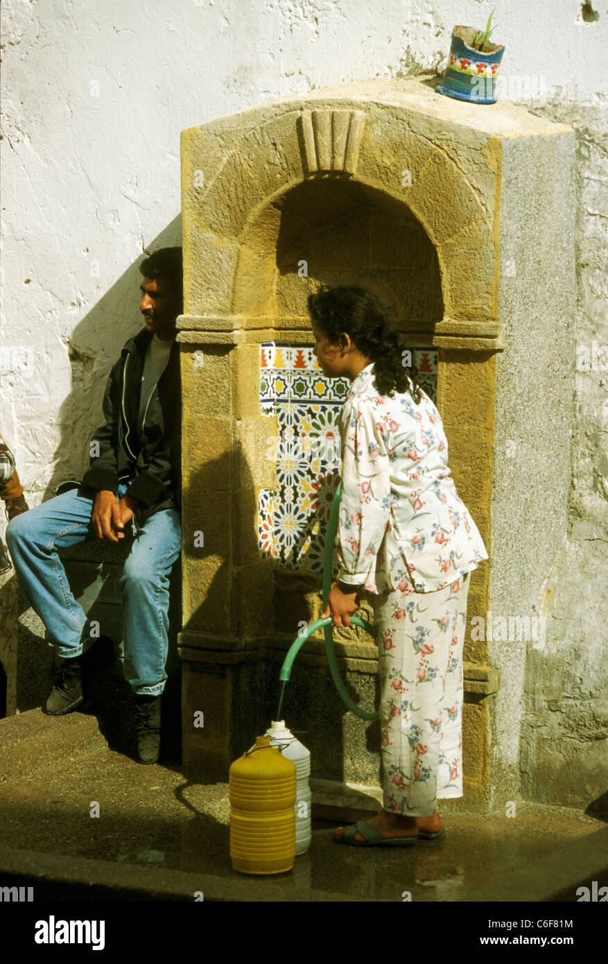 Woman filling barrels at a well in the Mellah, the old Jewish Quarter ...