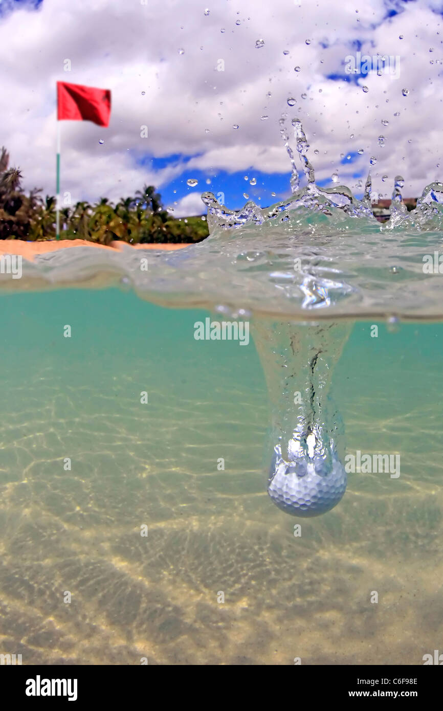 Over/ Under Shot of Golf Ball Splashing into Water Near Golf Flag Stock ...
