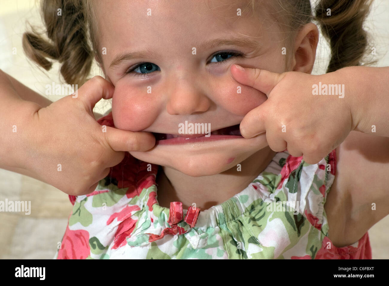 young toddlers girl face pulling cute pull a Stock Photo - Alamy