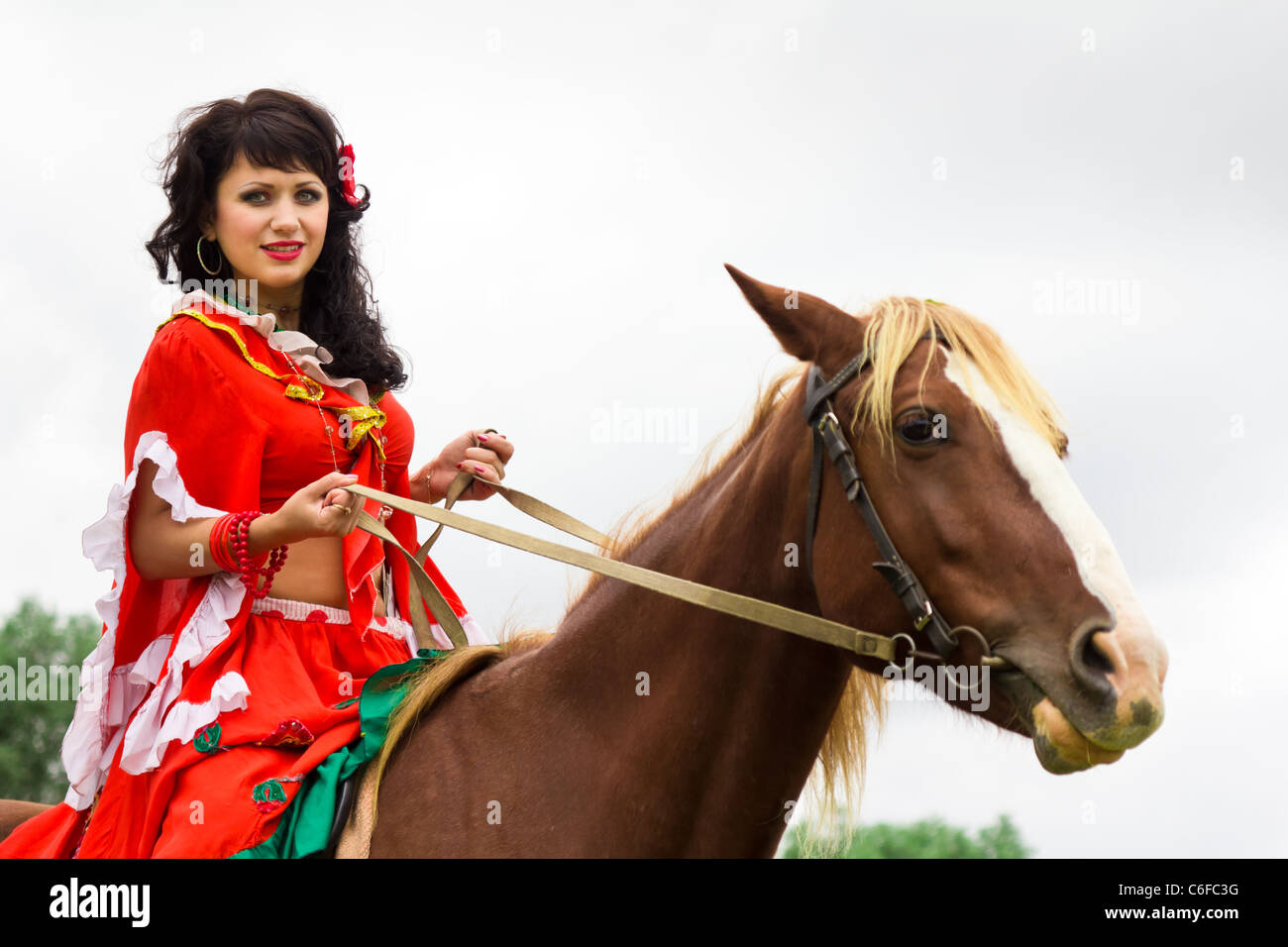 Beautiful gypsy girl riding a horse in the field Stock Photo - Alamy