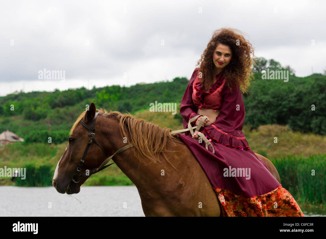 Beautiful gypsy girl riding a horse in the field Stock Photo - Alamy