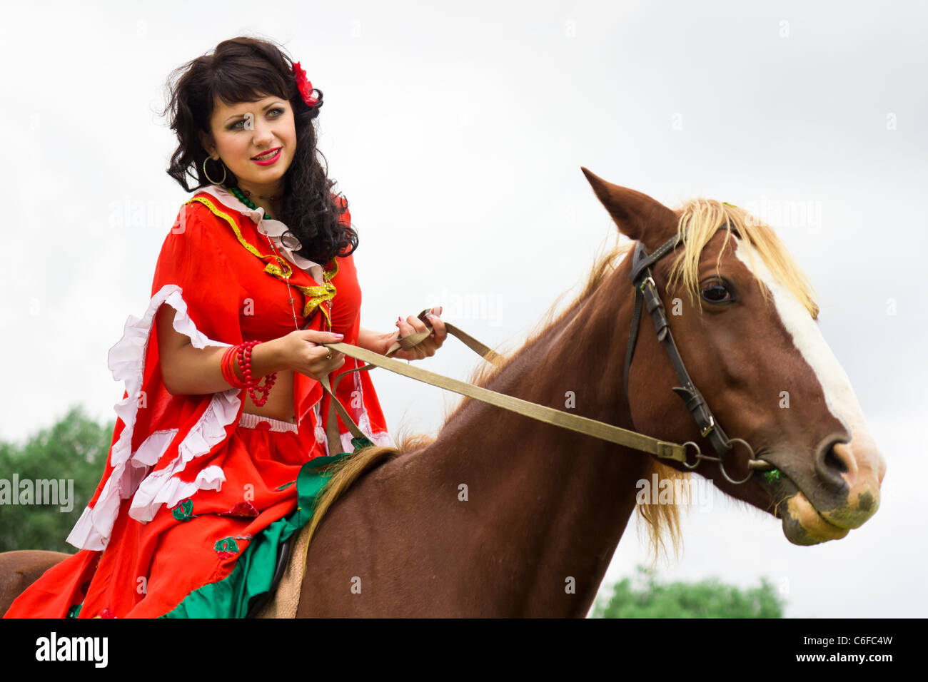 Beautiful gypsy girl riding a horse in the field Stock Photo - Alamy