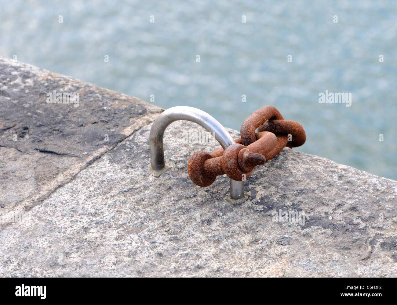 A stainless steel staple in the stone harbour wall with a rusty iron ...