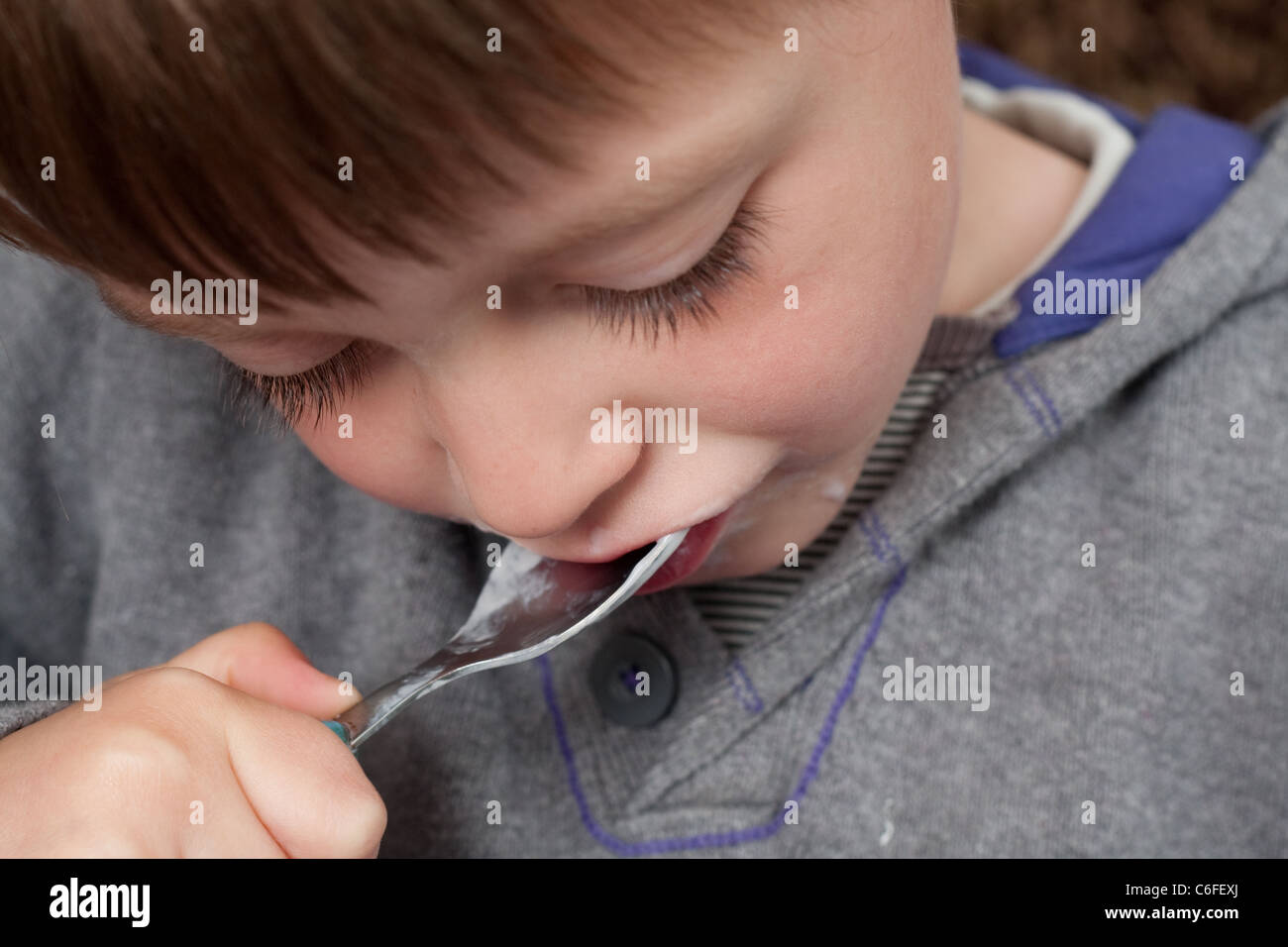Young child eating off a spoon Stock Photo - Alamy