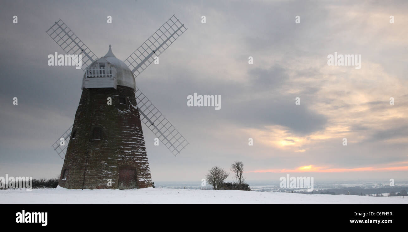 A snowy winter sunset at Halnaker Windmill in the South Downs National ...