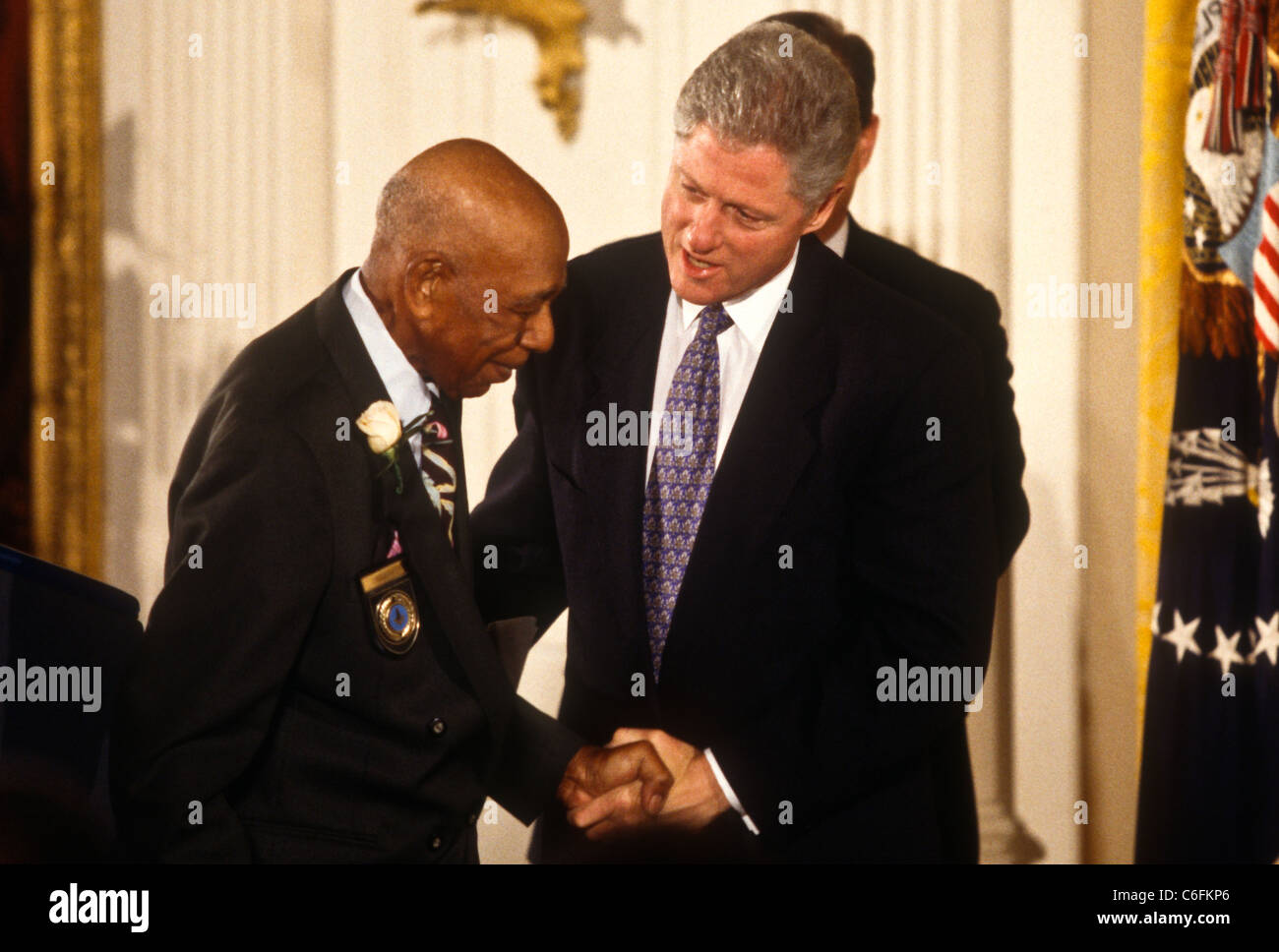 President Bill Clinton assists Herman Shaw, a survivor of the Tuskegee ...