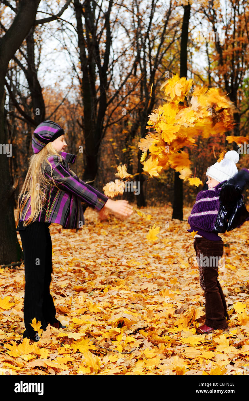 Children in autumn forest. Play fallen down leaf Stock Photo - Alamy