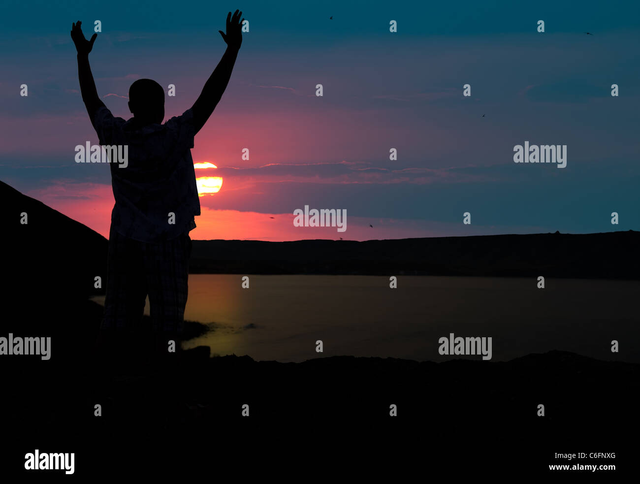 The man welcomes the sunset sun. Upwards the lifted hands Stock Photo ...
