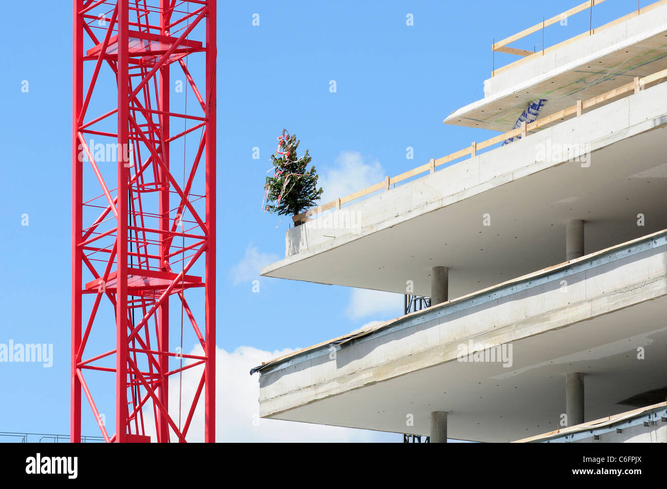 Red crane with topping-out tree at a construction site Stock Photo - Alamy