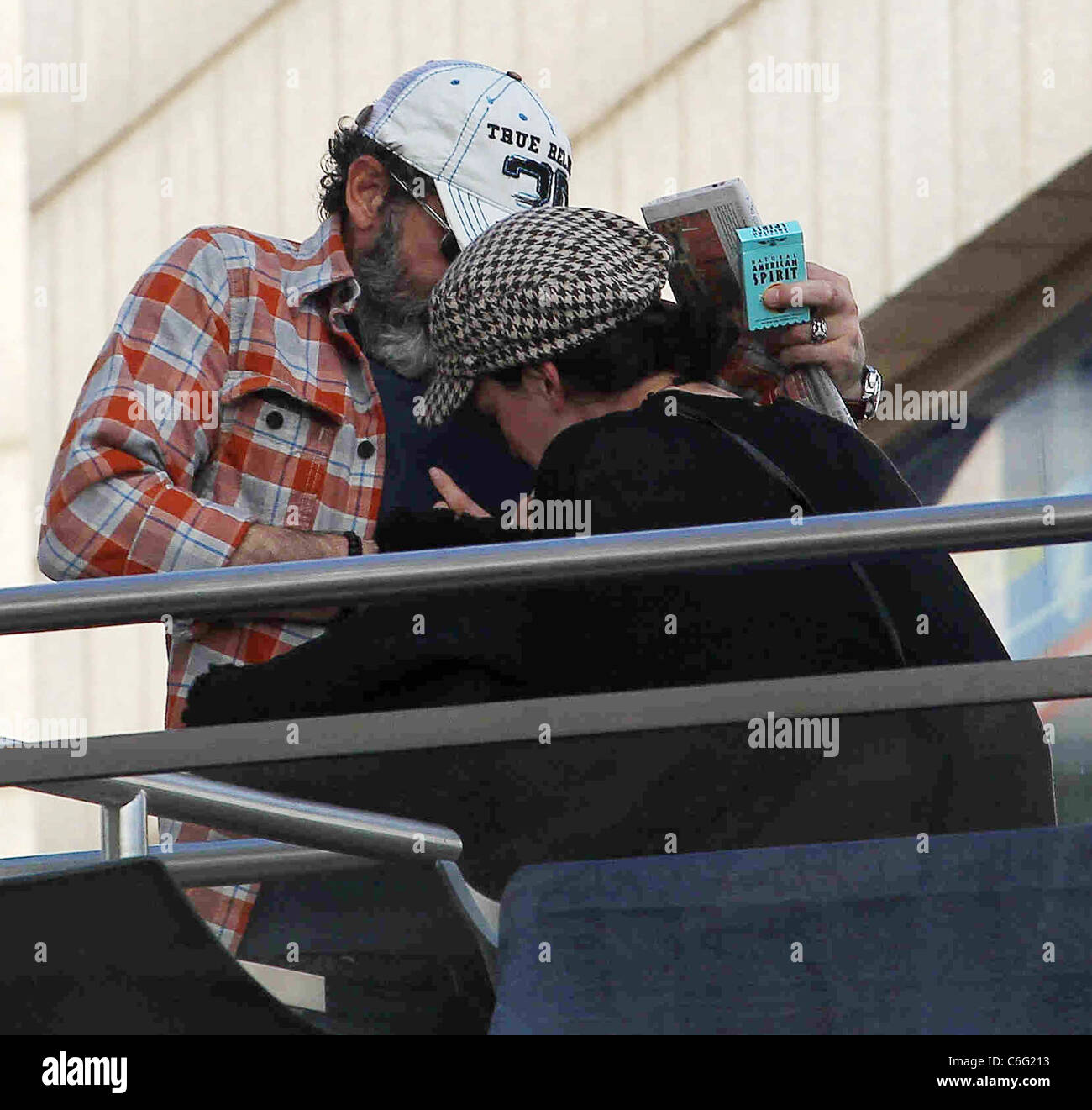 Antonio Banderas tries to block the wind as he lights a cigarette with ...