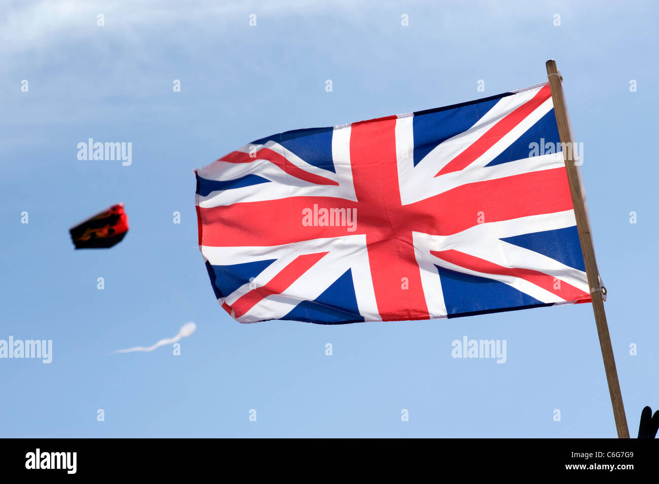 union jack flag flying against a blue sky with kites flying behind ...