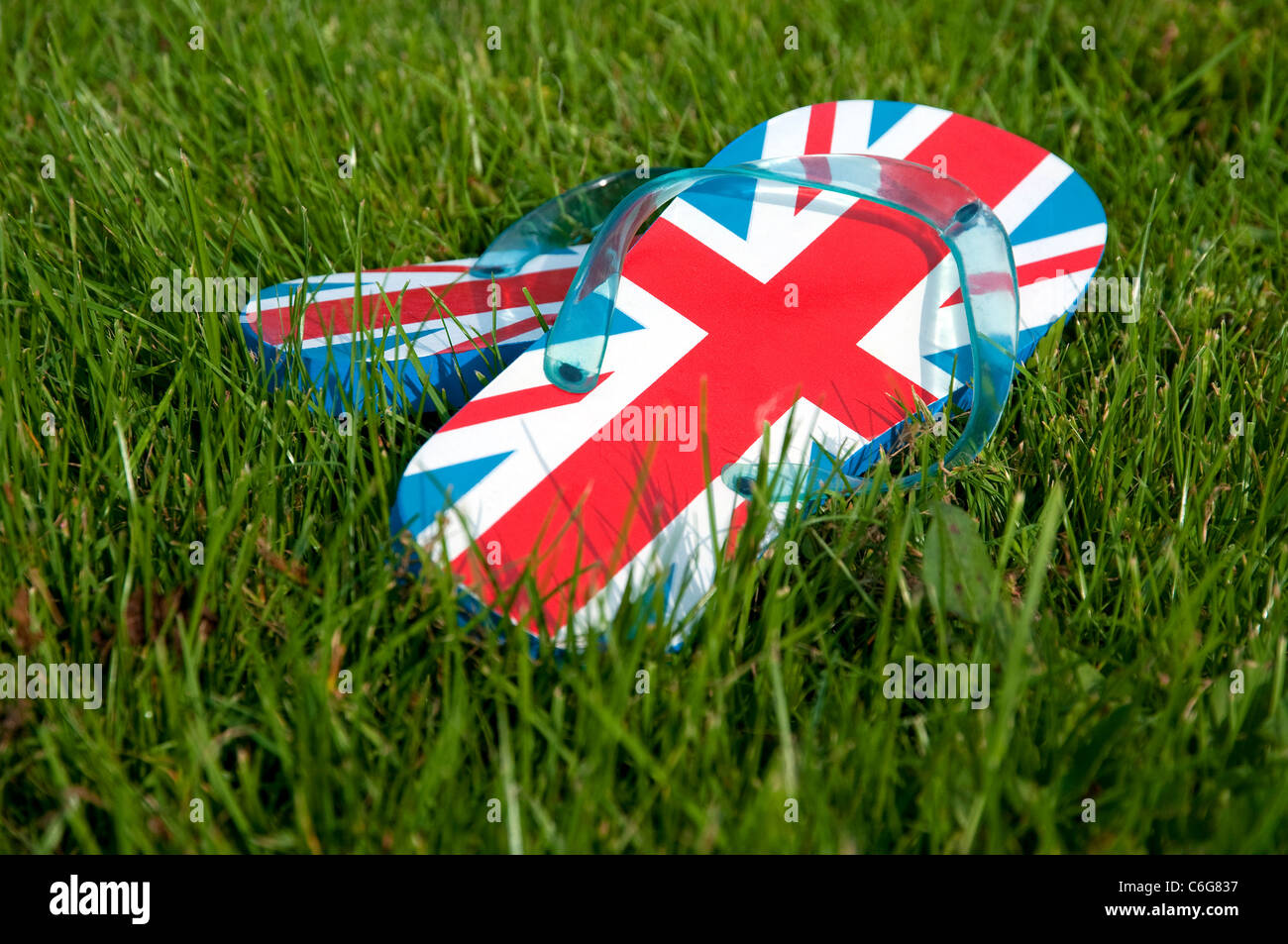 union jack flip flops on green grass lawn Stock Photo - Alamy