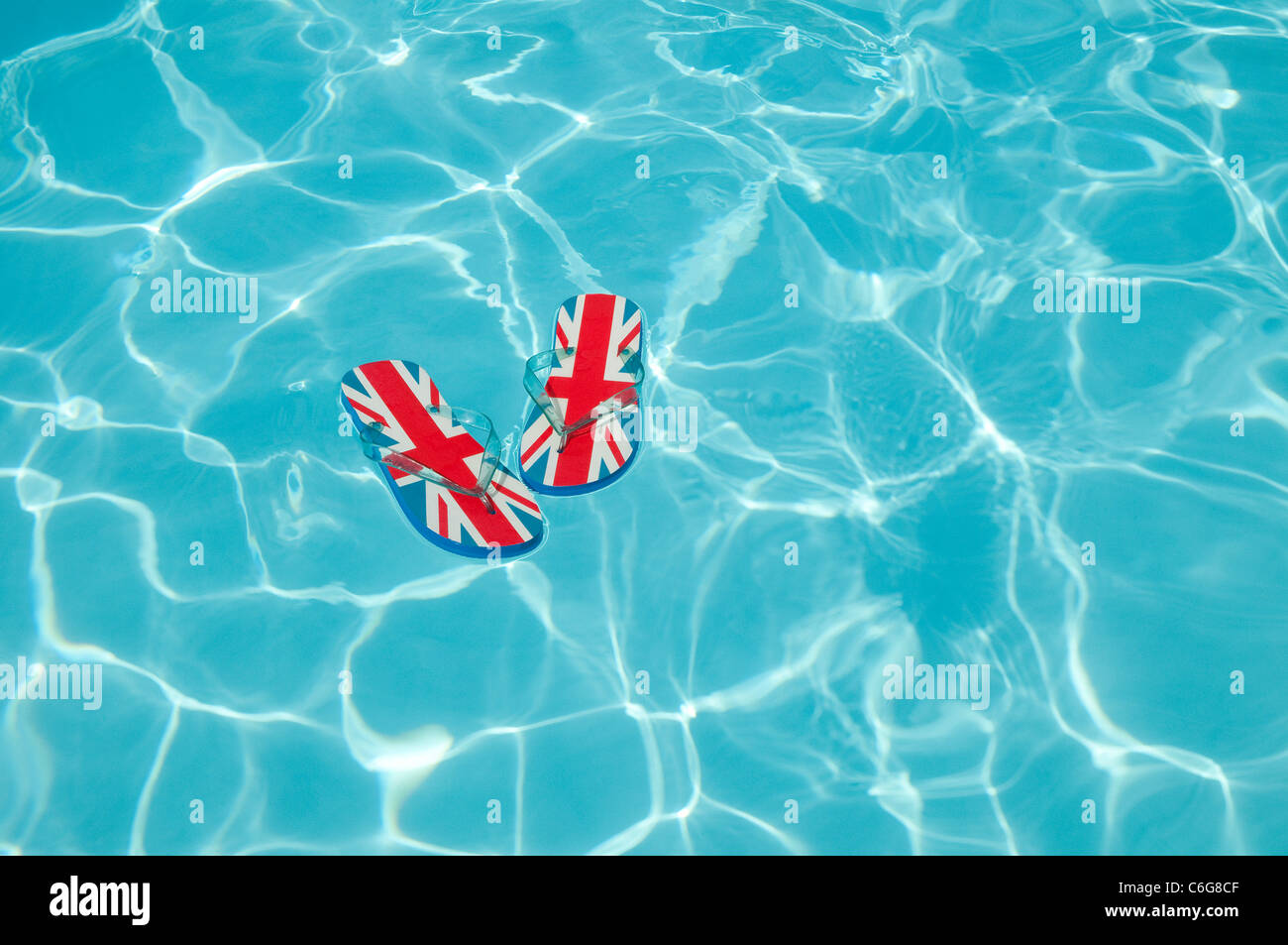 union jack flip flops floating in swimming pool Stock Photo - Alamy