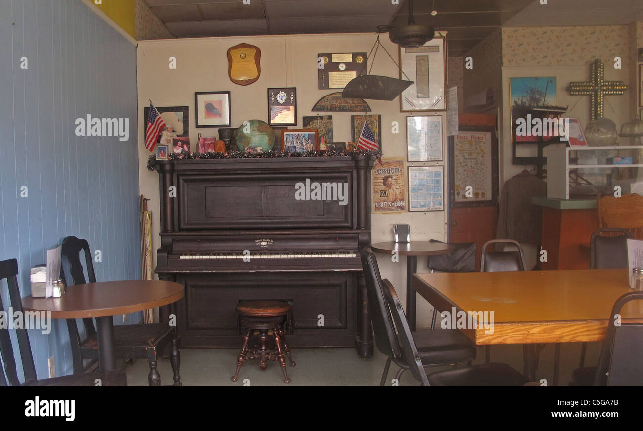 Small town restaurant interior with piano and cross Stock Photo - Alamy