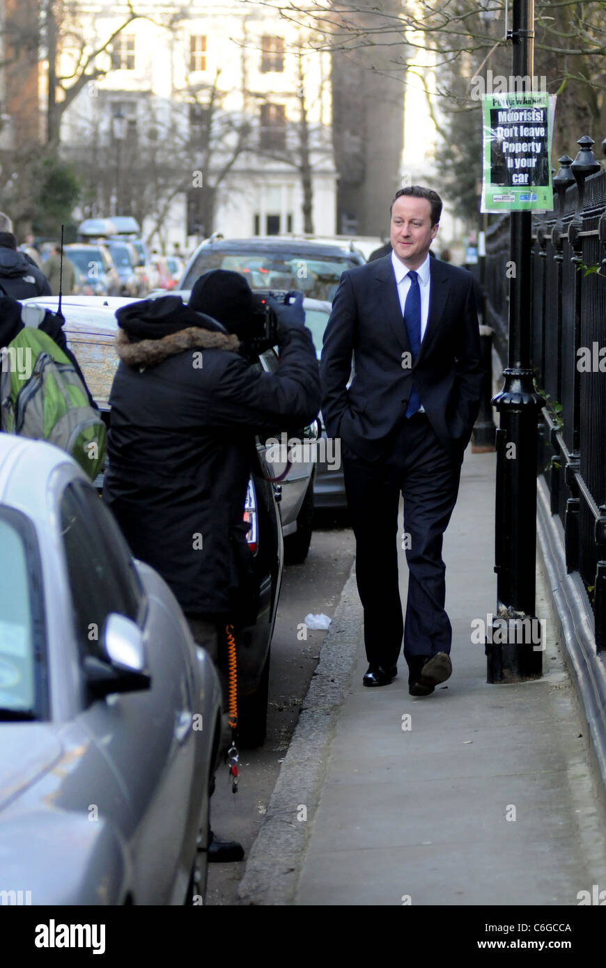 David Cameron makes his way home after taking his children to school ...