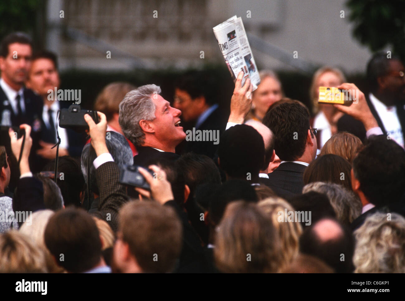 President Bill Clinton holds up a newspaper announcing his re-election ...