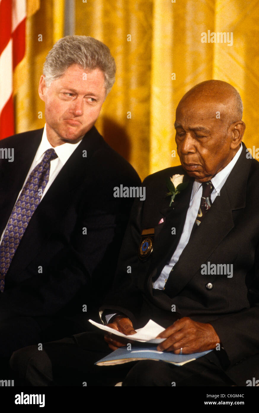 President Bill Clinton looks toward Herman Shaw, a survivor of the ...