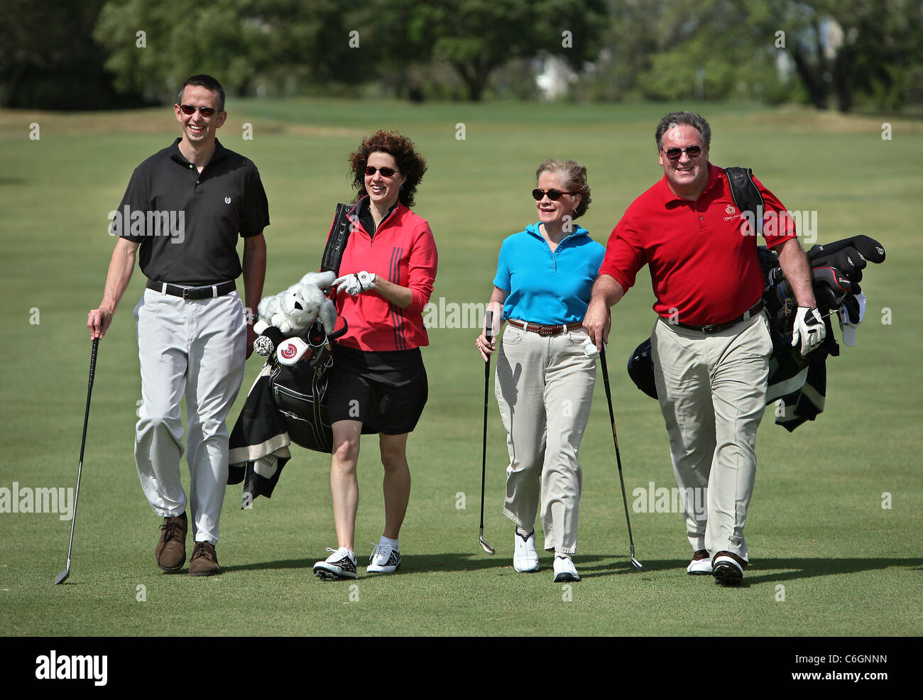 Golfers walk down a fairway golf course for an active healthy lifestyle ...