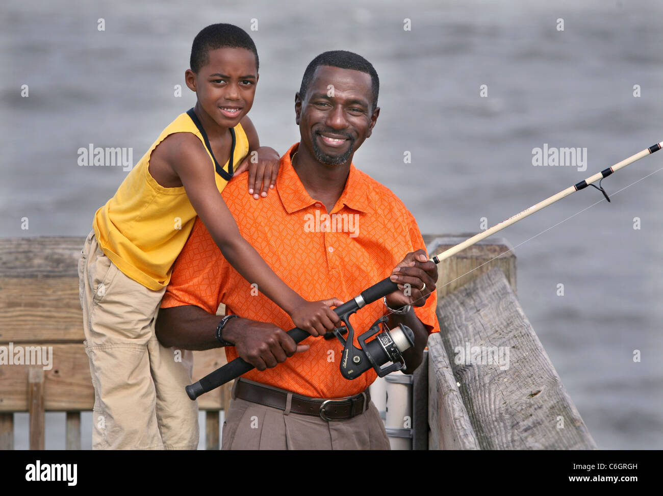 African-American father and son fishing off the fishing pier at Folly ...