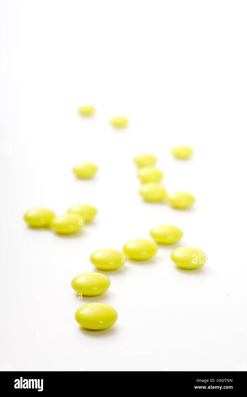 yellow medical tablets, over white Stock Photo - Alamy